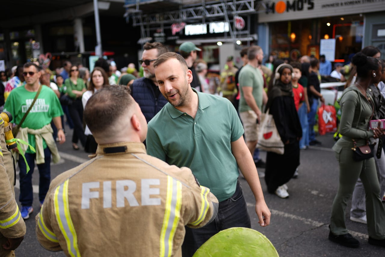 Grenfell demonstrators embrace firefighters during anniversary march ...