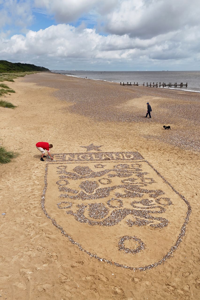 Artist crafts England badge on beach as World Cup campaign nears kick ...