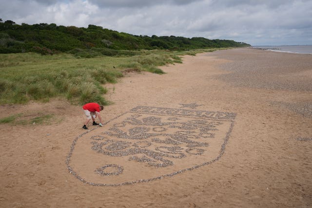 Artist crafts England badge on beach as World Cup campaign nears kick ...